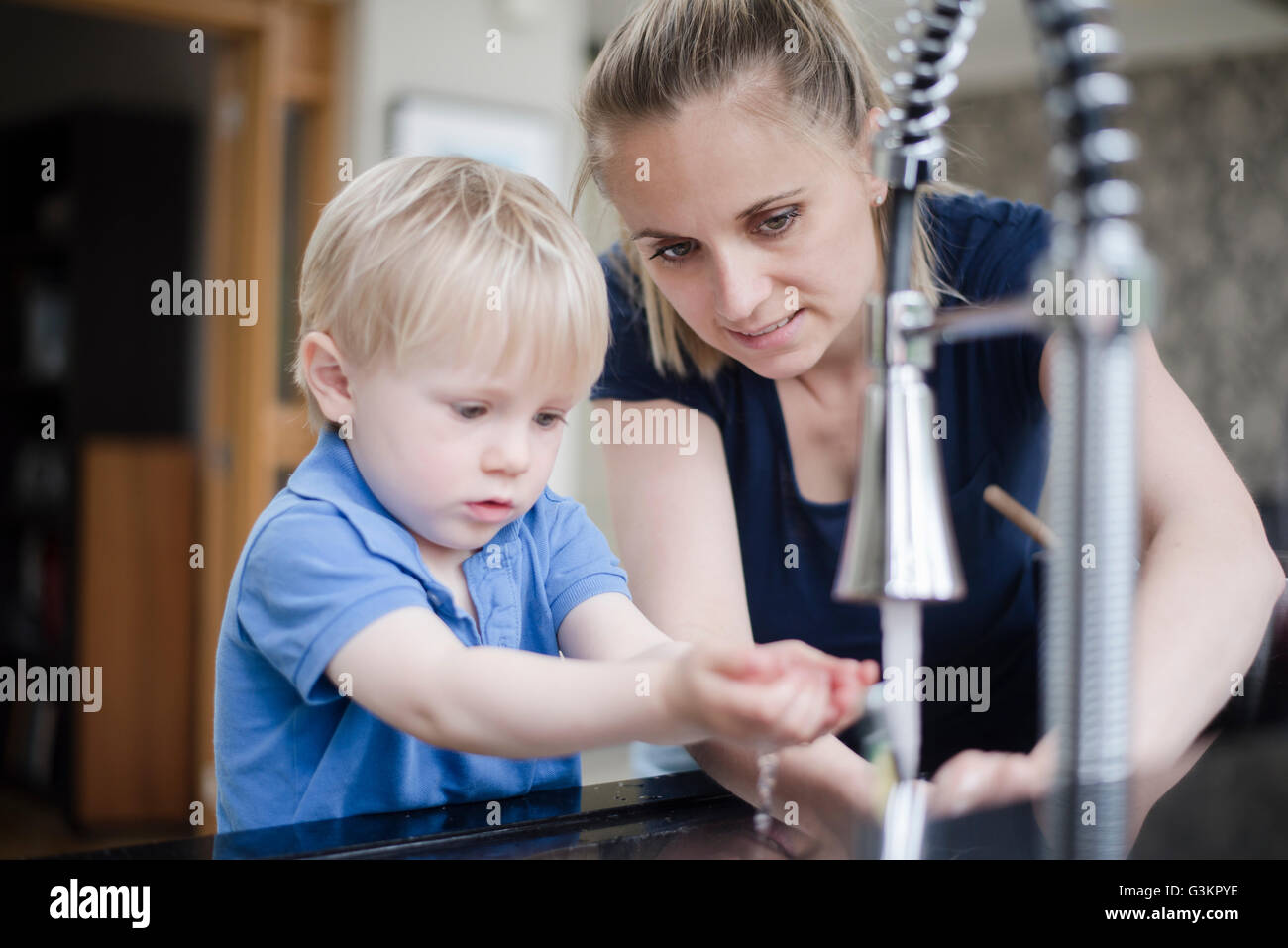 Mother helping son wash his hands Stock Photo - Alamy