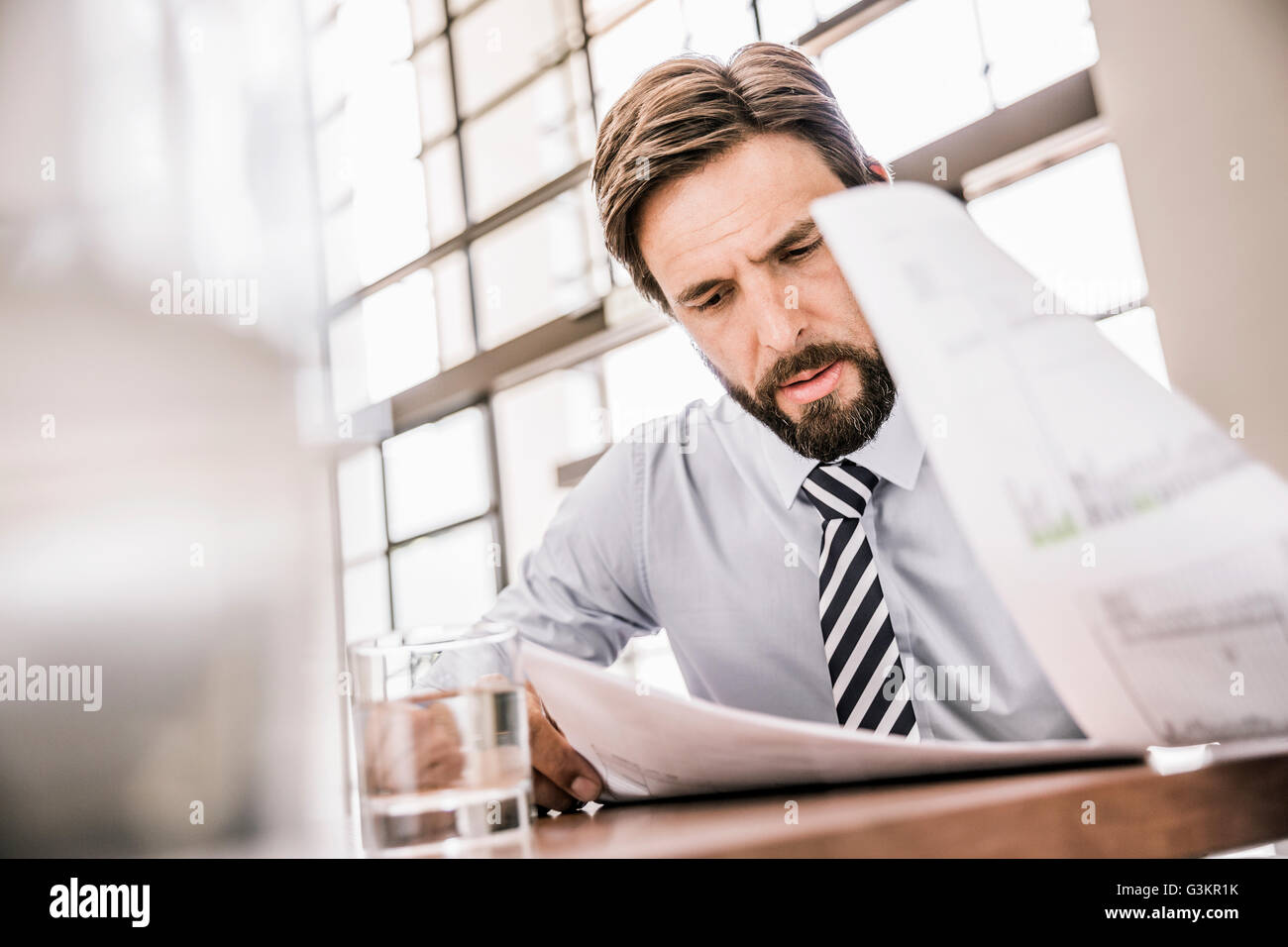 Bearded businessman looking down at paperwork Stock Photo - Alamy