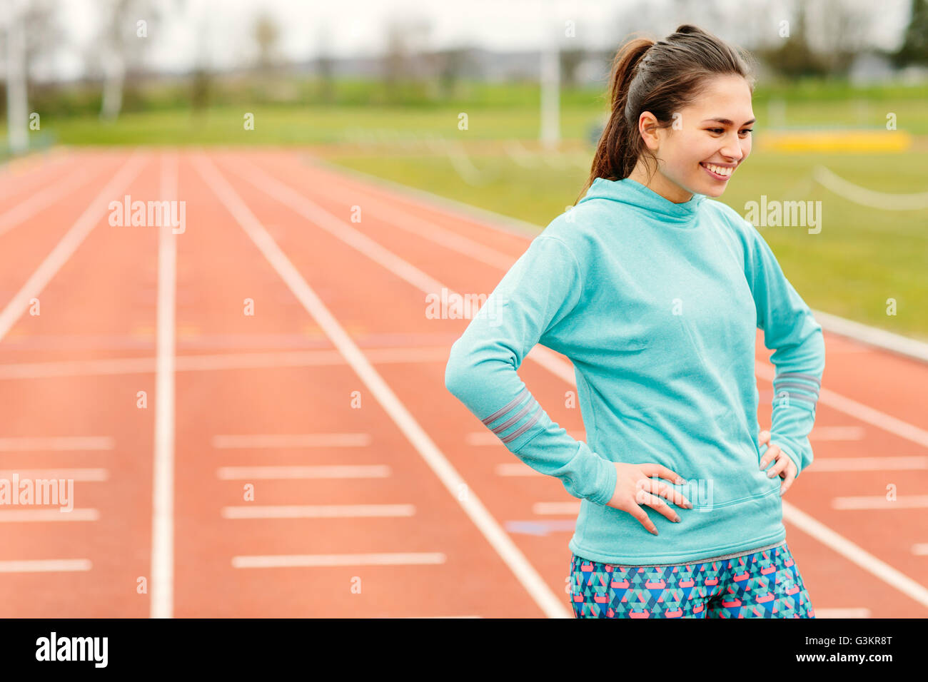 Portrait of young girl on running track, smiling Stock Photo - Alamy