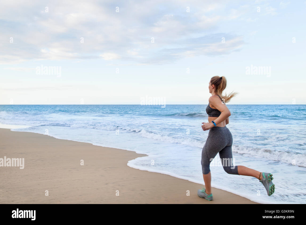 Female runner running on beach hi-res stock photography and images - Alamy