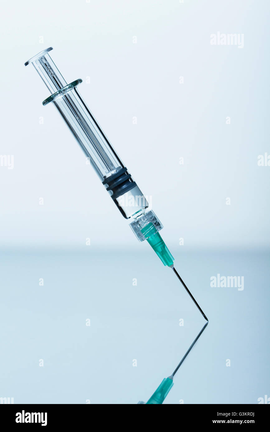 Syringe with needle standing upright Stock Photo - Alamy