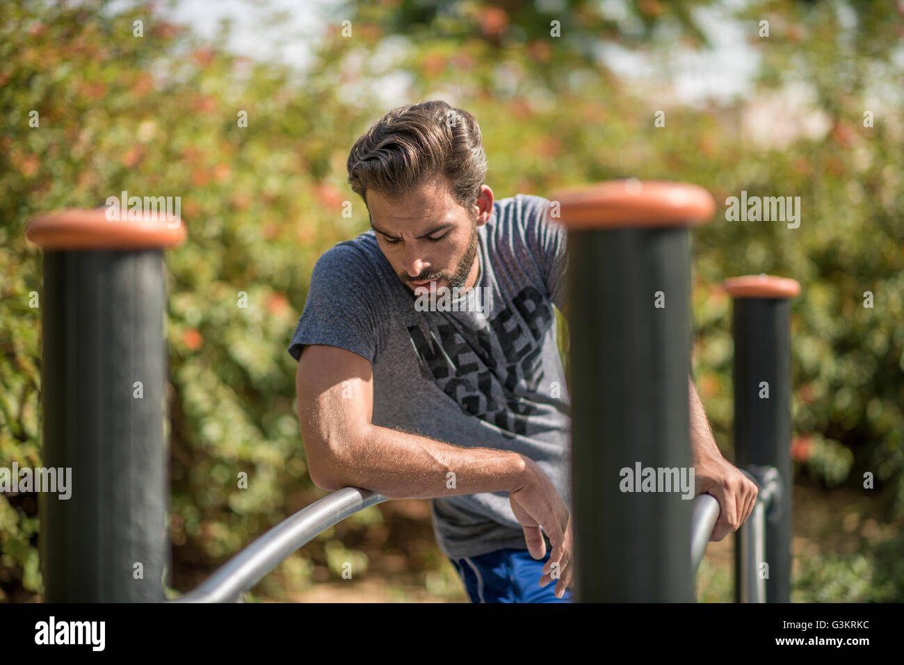 Young man using park exercise equipment, Dubai, United Arab Emirates ...