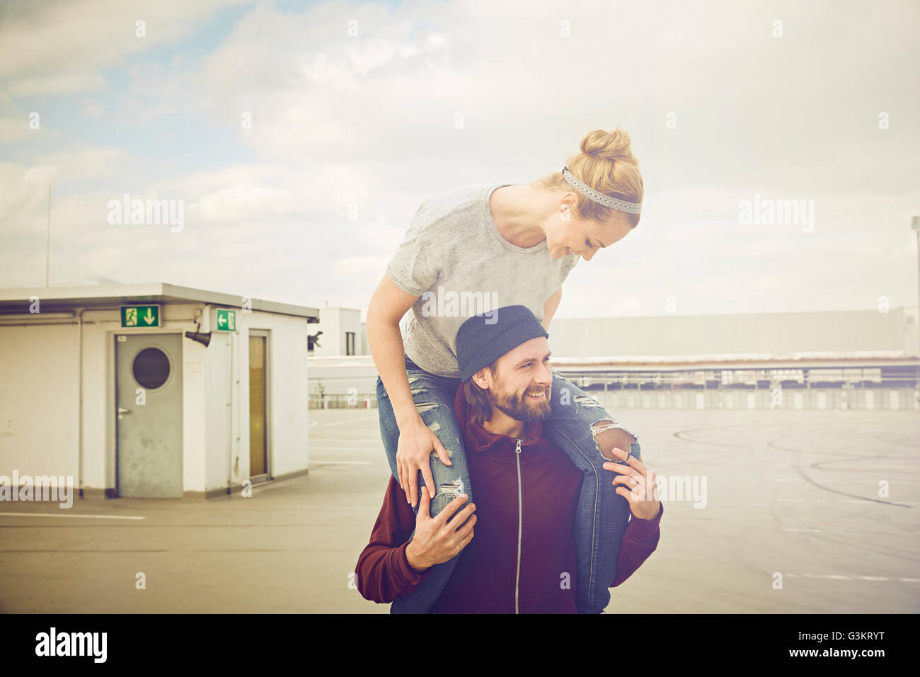 Mid adult woman getting shoulder ride from boyfriend on rooftop parking ...