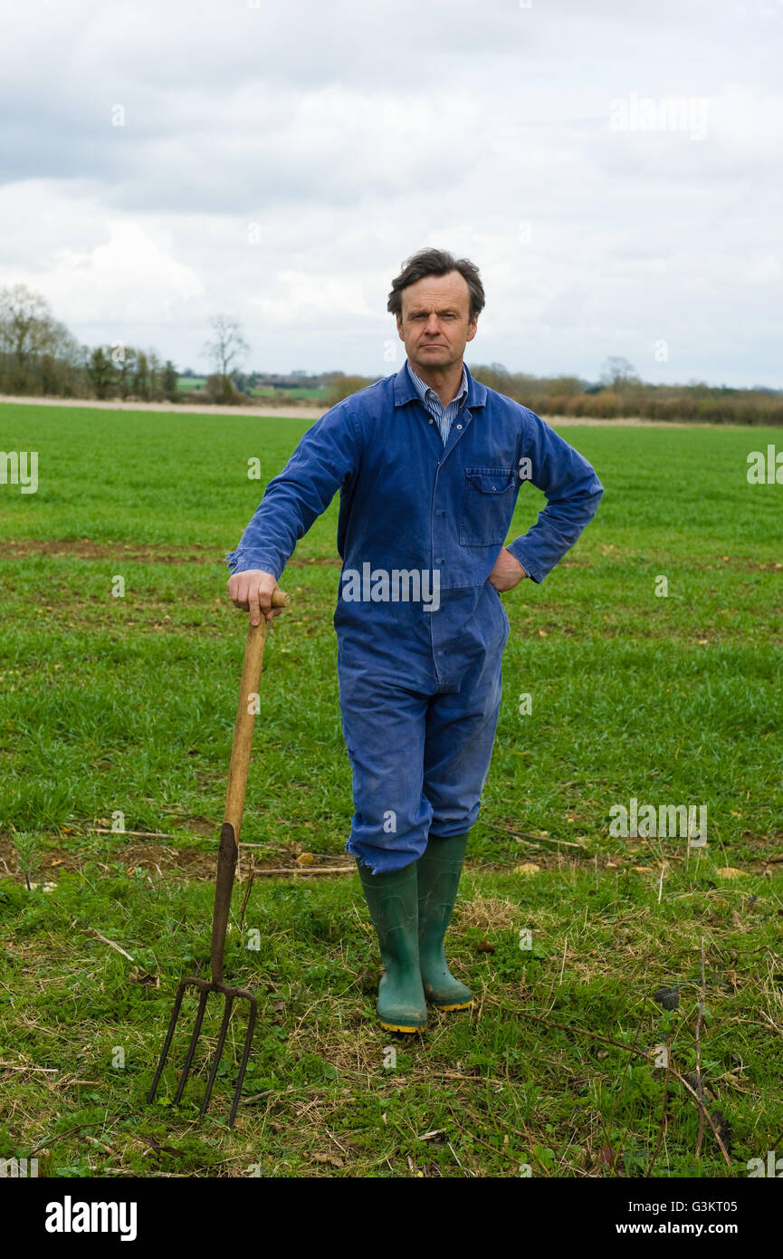 Portrait of farmer leaning on pitch fork in field Stock Photo - Alamy