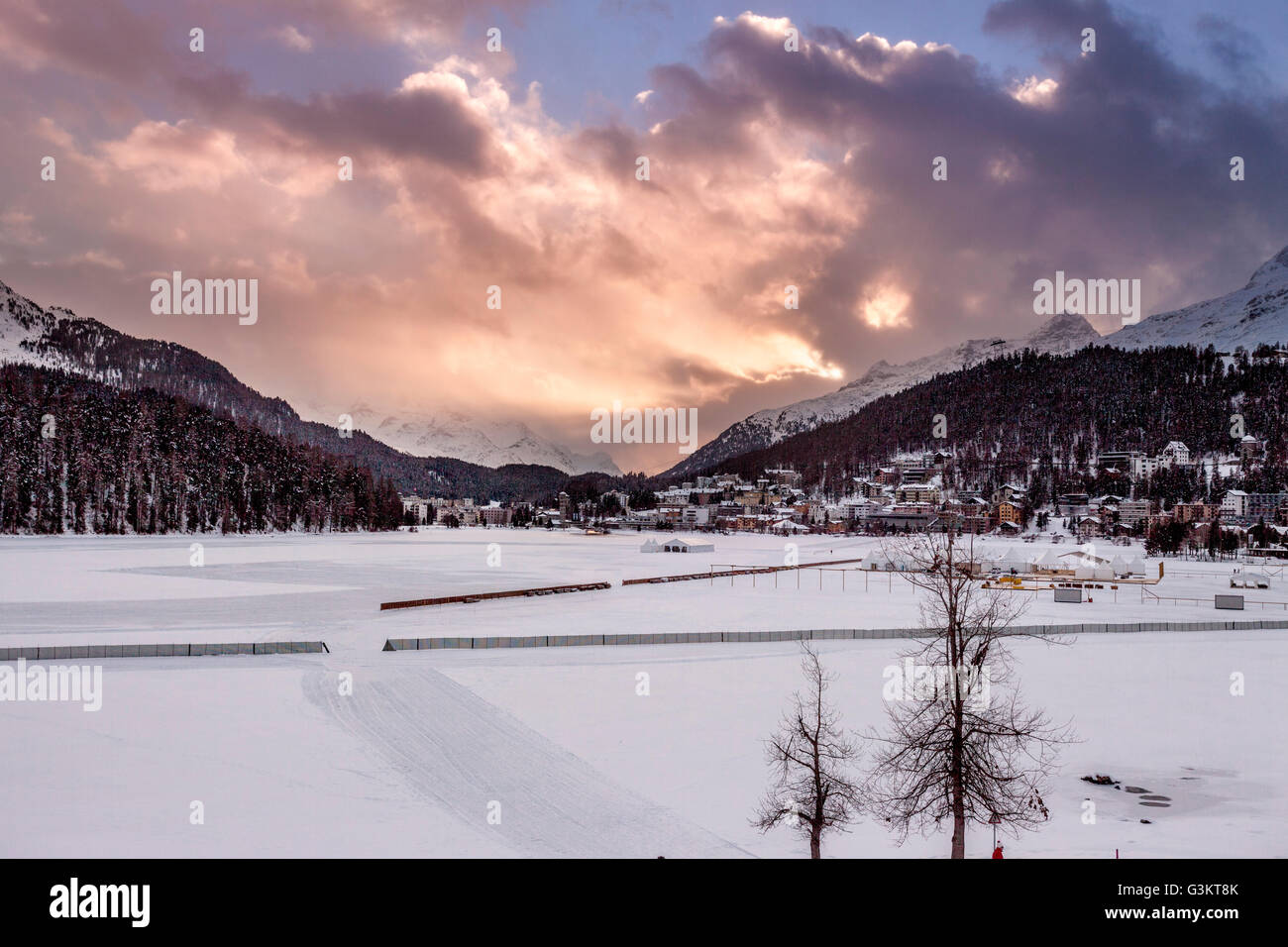Village beneath mountain on snow covered landscape at sunset, Sankt ...