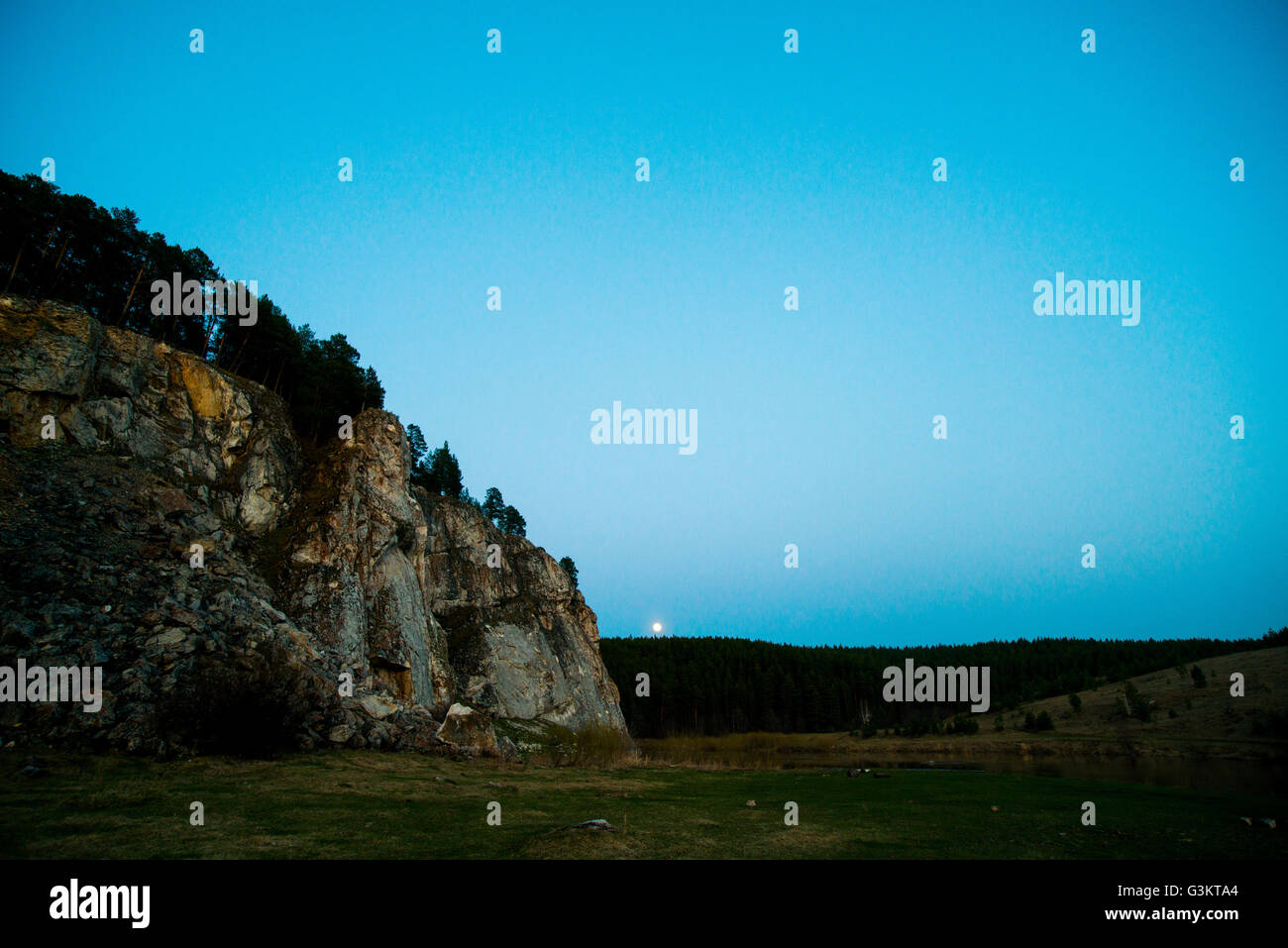 Rock face in rolling landscape Stock Photo - Alamy