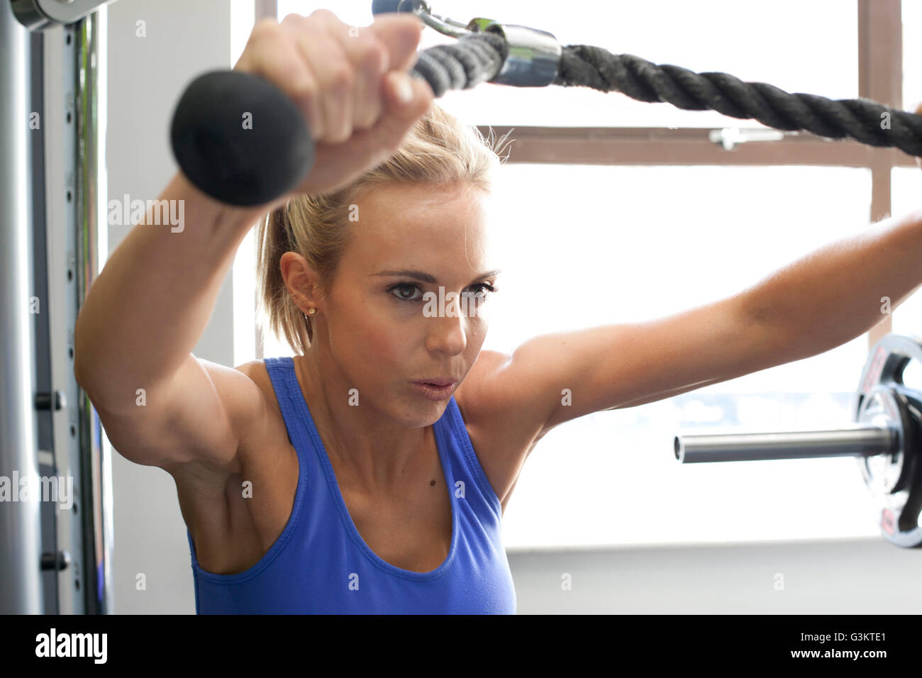 Woman in gym using exercise machine Stock Photo - Alamy