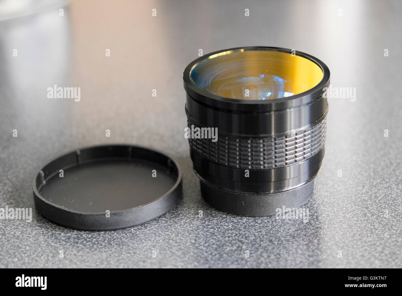 Camera lens and lid on table Stock Photo - Alamy