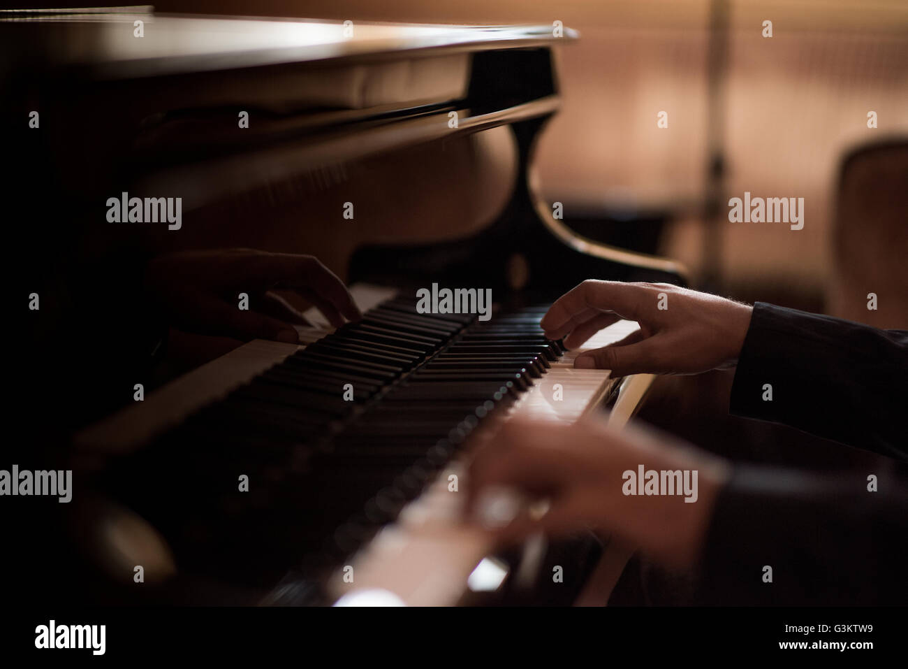 Hands of young man playing piano keys in bar at night Stock Photo - Alamy