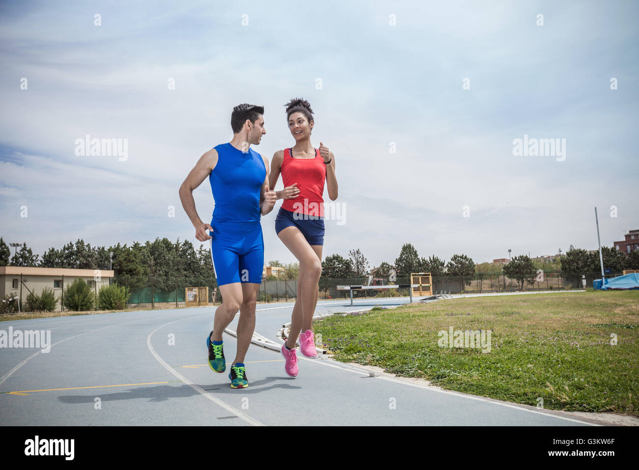 Young male and female runners training on running track Stock Photo - Alamy