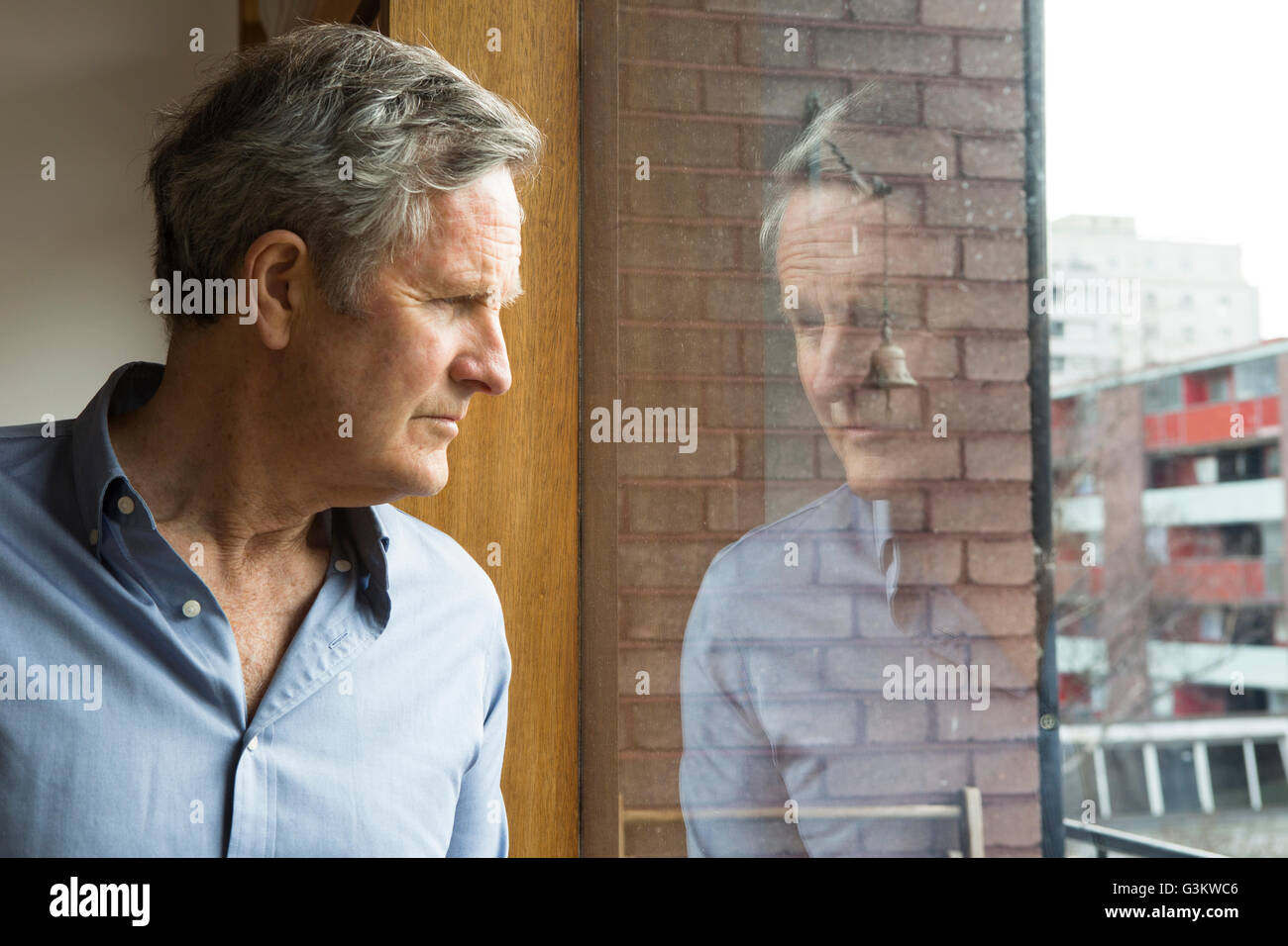 Man looking through window Stock Photo - Alamy