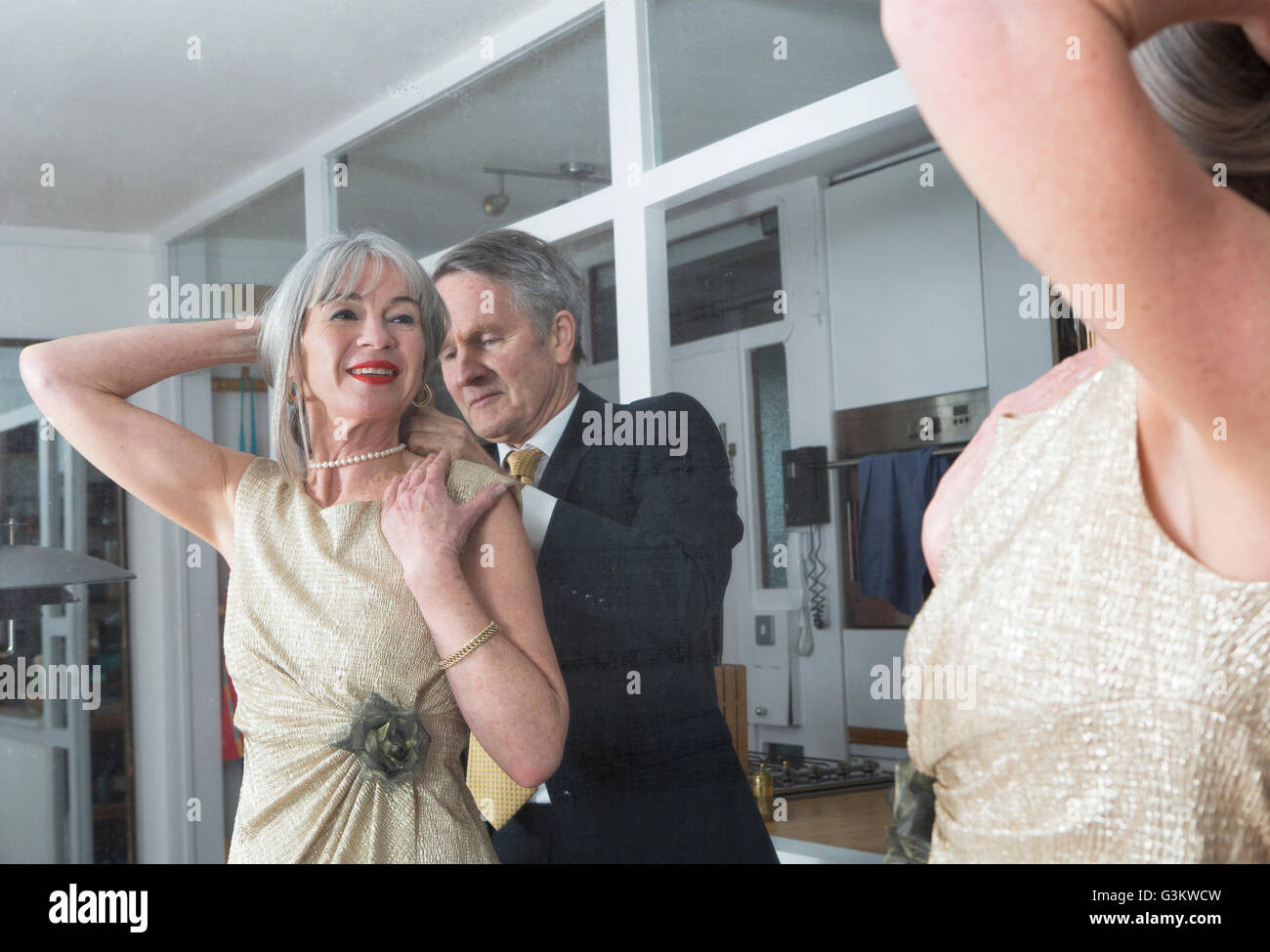 Couple dressing up getting ready in front of mirror Stock Photo - Alamy