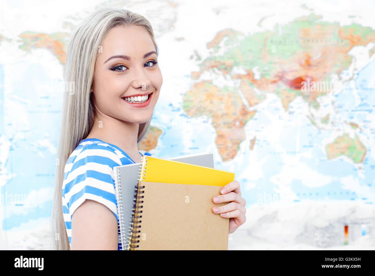 Beautiful young woman near map Stock Photo - Alamy