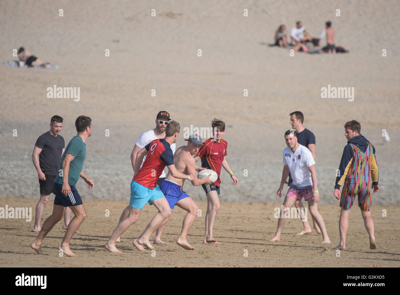A group of young men playing rugby on Fistral Beach in Newquay ...