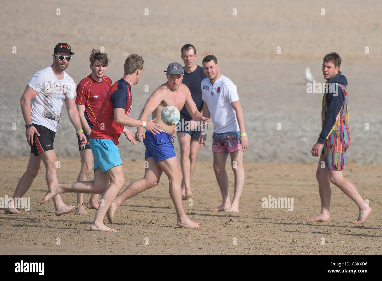 A group of young man playing rugby on Fistral Beach in Newquay ...