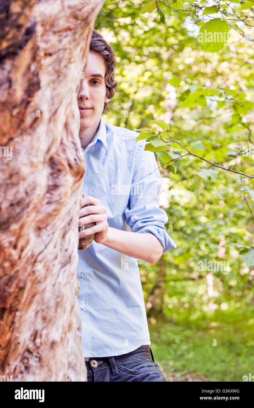 Young man standing by a tree in the woods, Sweden, Europe Stock Photo ...