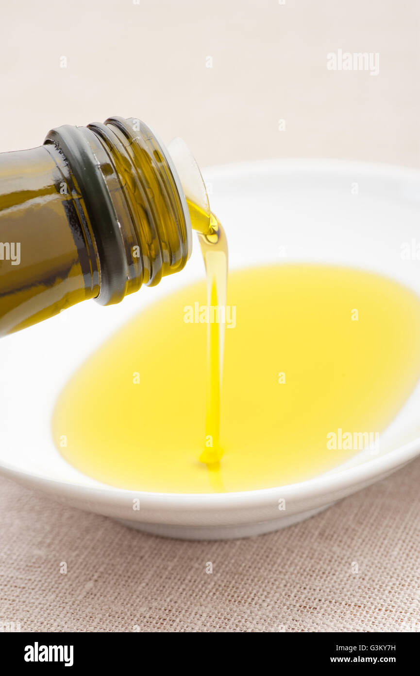 Olive oil being poured onto plate Stock Photo - Alamy