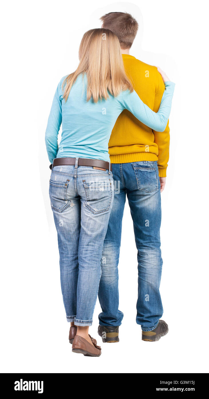 Back view of young embracing couple (man and woman) hug and look into ...