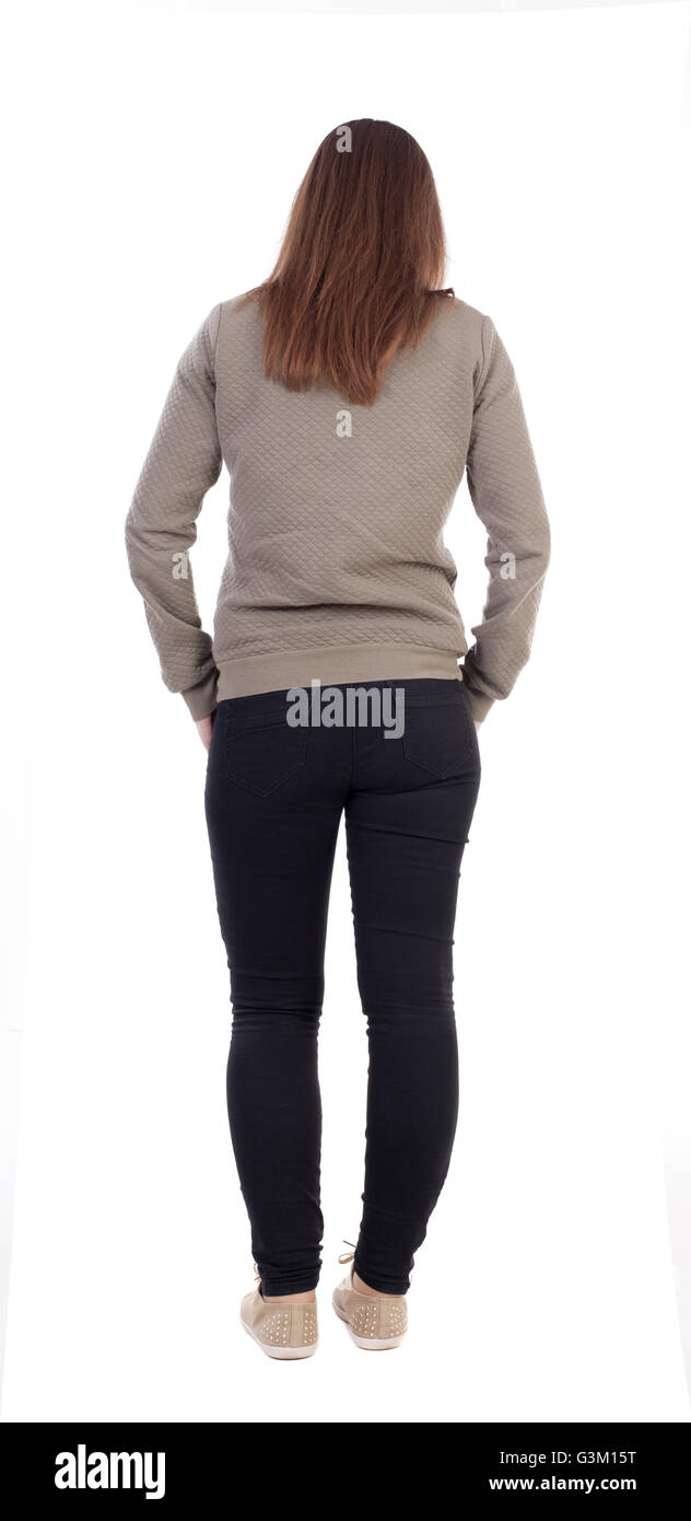 back view of standing young beautiful woman in jeans. girl watching ...
