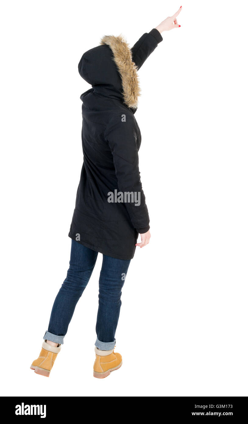 Back view of pointing young women in parka. Young girl gesture. Rear ...