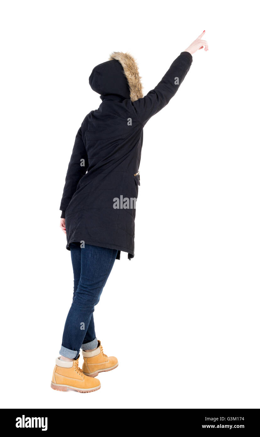 Back view of pointing young women in parka. Young girl gesture. Rear ...