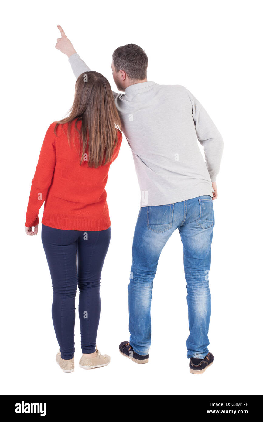 young couple pointing at wal Back view (woman and man). Rear view ...