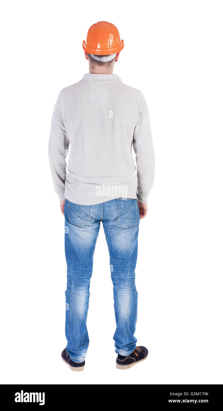 Backview of an engineer in construction helmet stands. Standing young ...