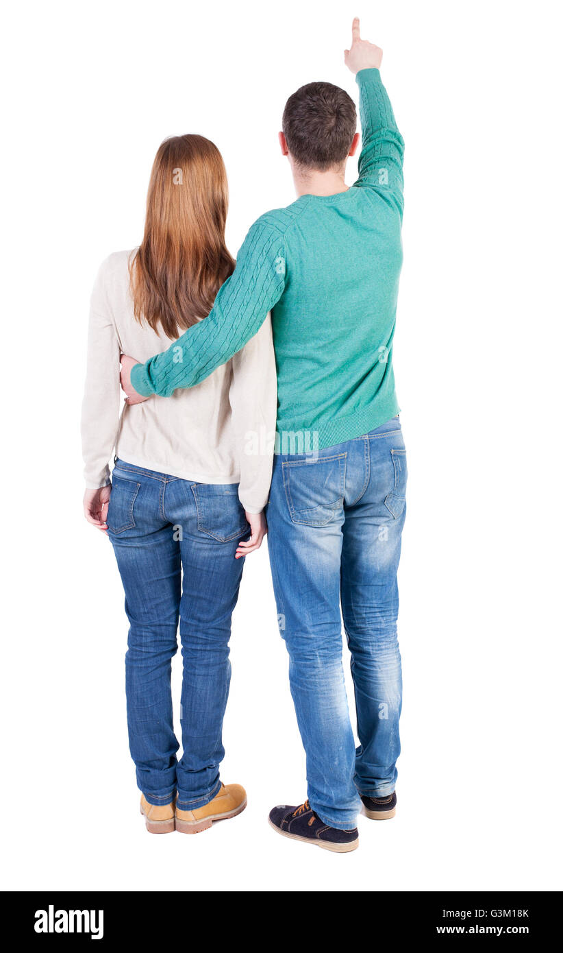 young couple pointing at wal Back view (woman and man). Rear view ...