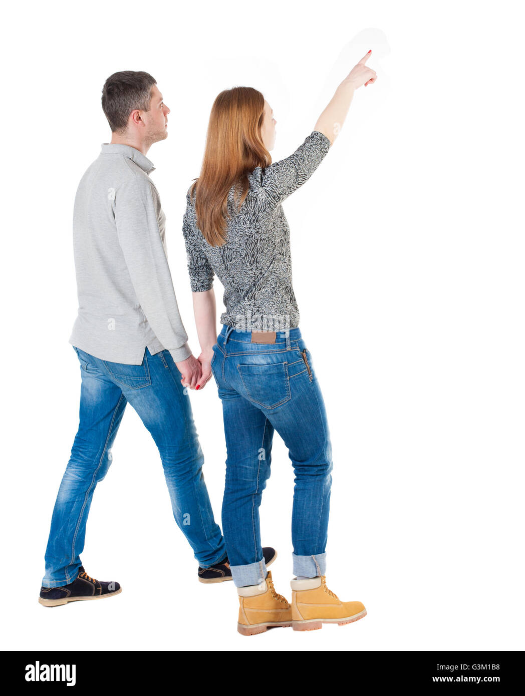 Back view of walking young couple (man and woman) pointing. Rear view ...