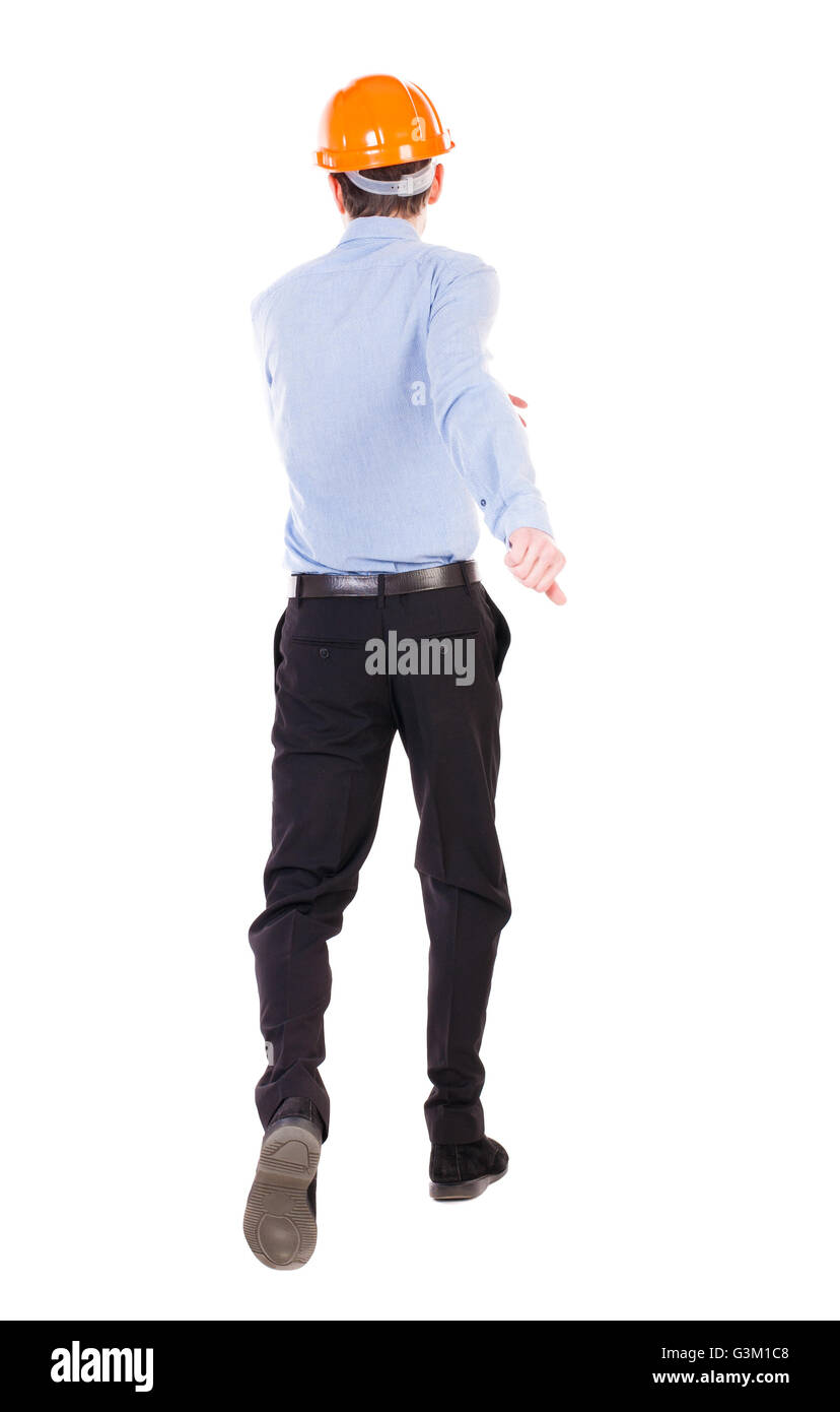 Back view of running engineer in helmet. Walking guy in motion. Rear ...