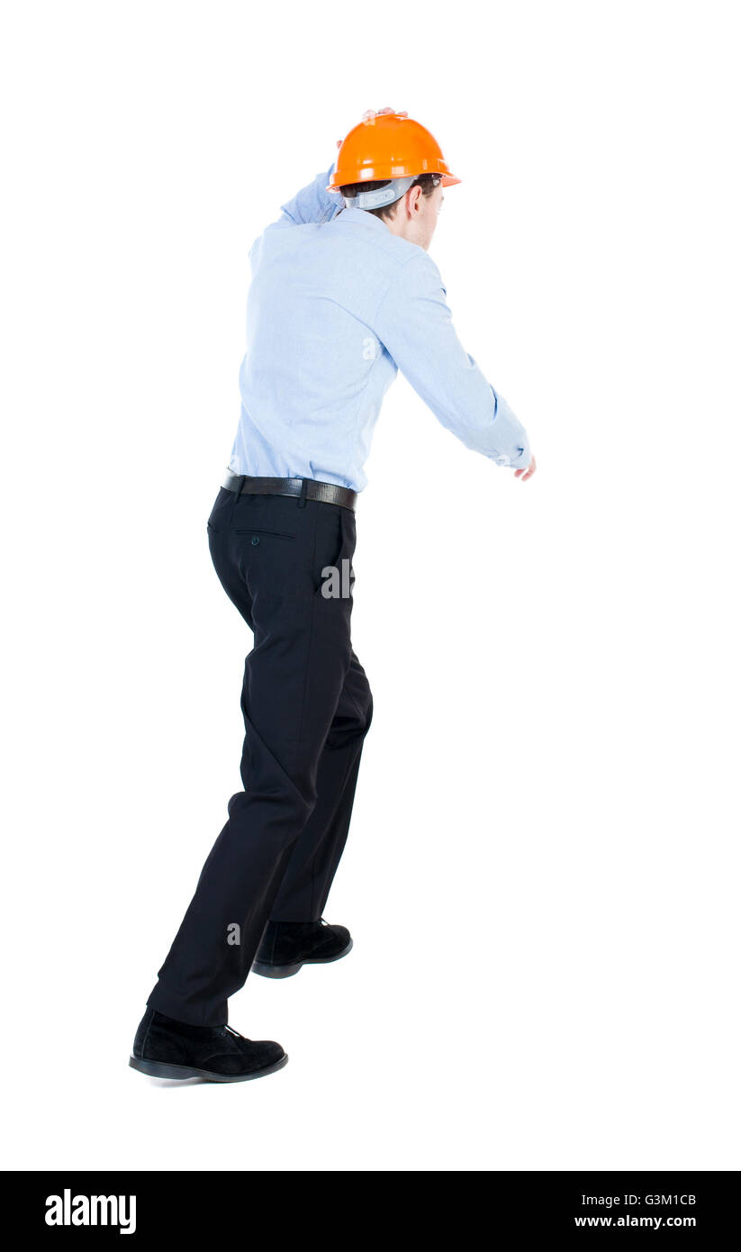 Back view of running engineer in helmet. Walking guy in motion. Rear ...