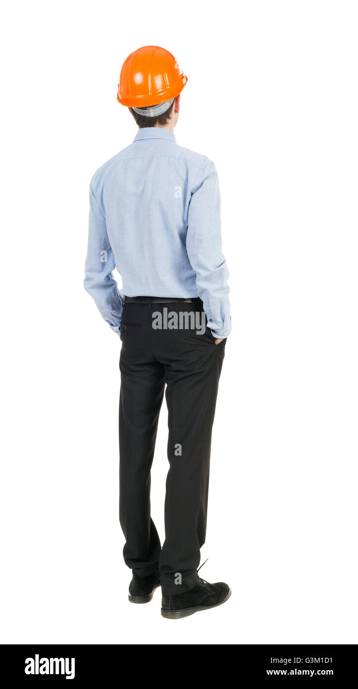 Backview of an engineer in construction helmet stands. Standing young ...
