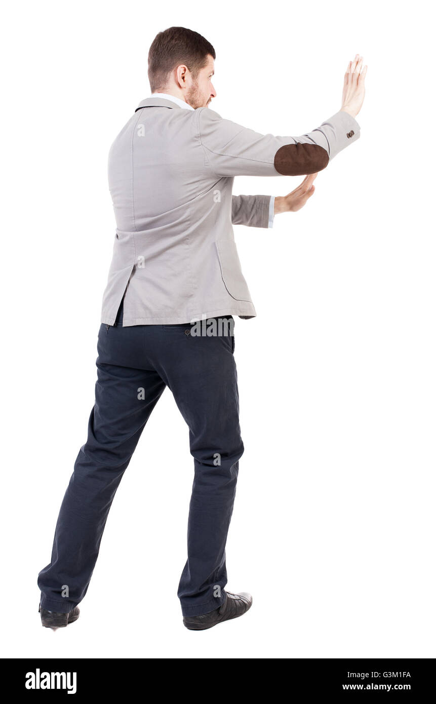 back view of business man pushes wall. Isolated over white background ...