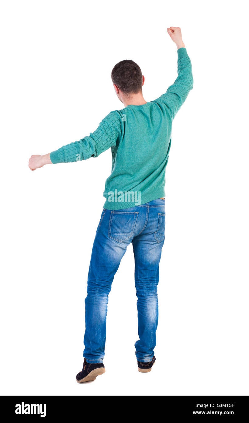 Back view of man. Raised his fist up in victory sign. Rear view people ...