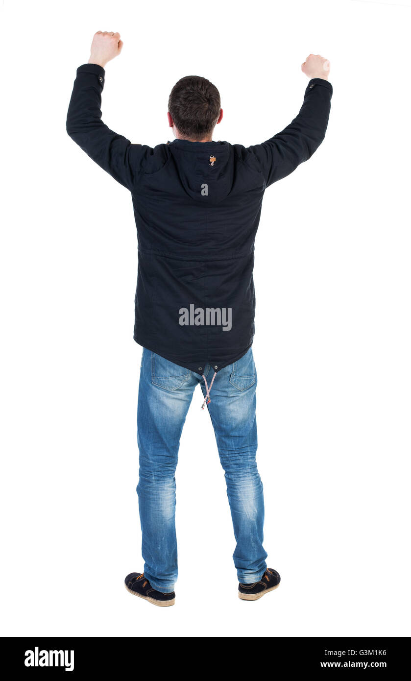 Back view of man. Raised his fist up in victory sign. Rear view people ...