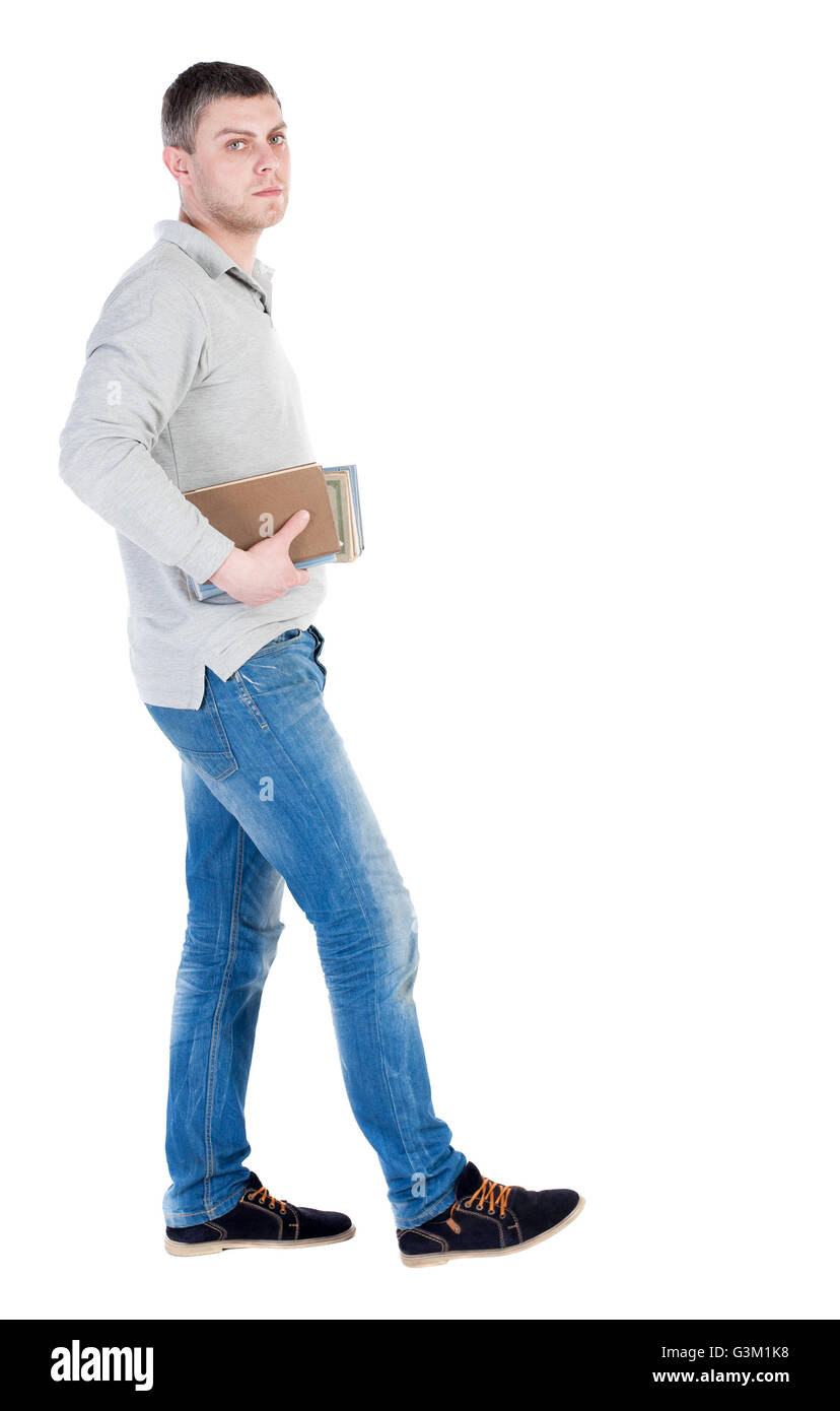Back view of going handsome man carries a stack of books. walking young ...