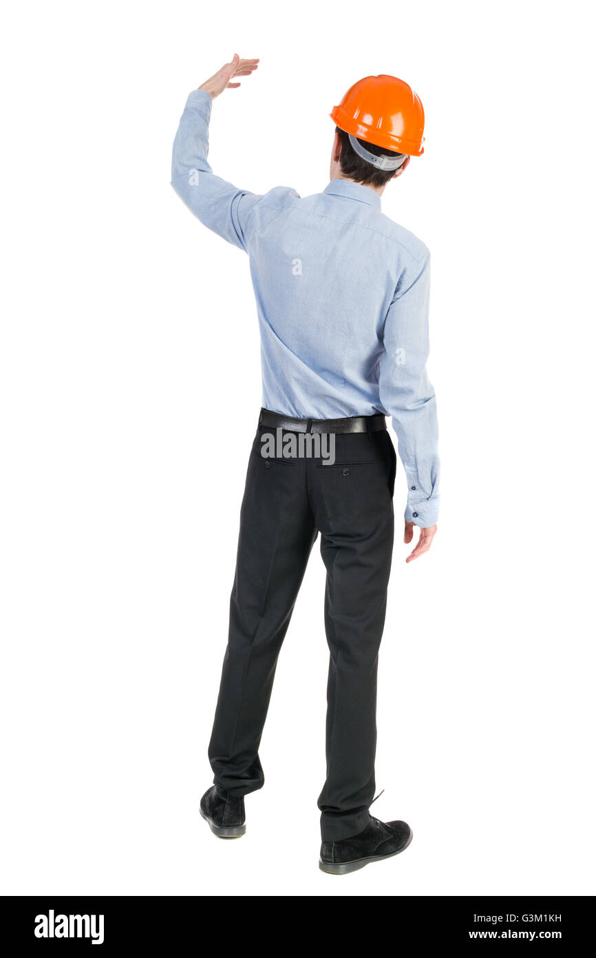 Backview of an engineer in construction helmet stands. Standing young ...