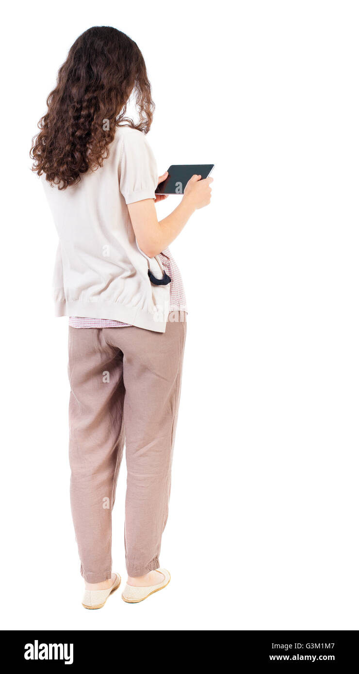back view of standing young beautiful girl with tablet computer in the ...