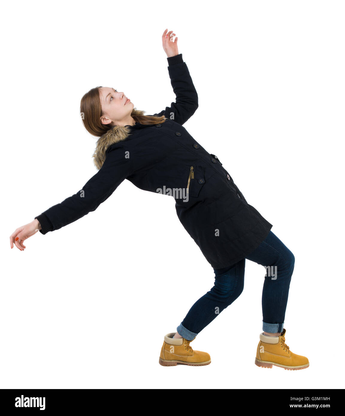 Balancing young woman in parka. or dodge falling woman. Rear view ...