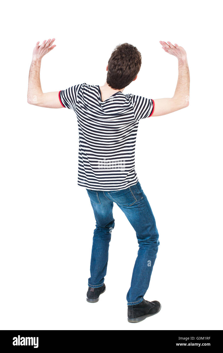 back view. man protects hands from what is falling from above. Man ...