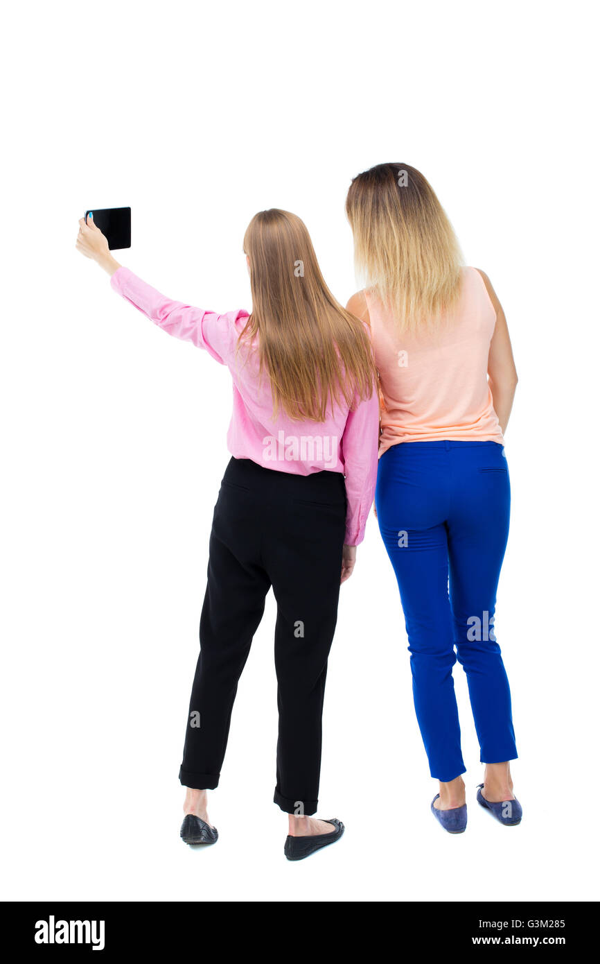 Back view of two young woman photographed on a mobile phone. Rear view ...