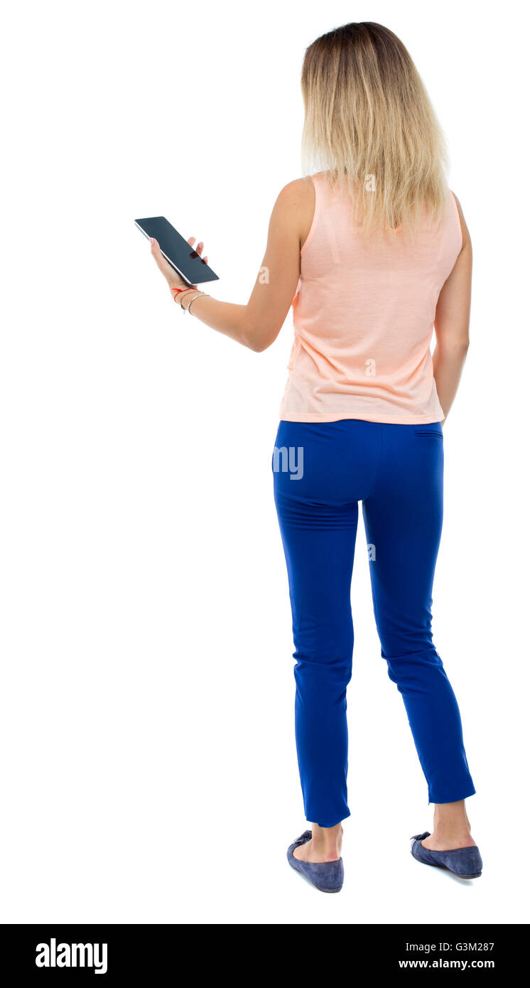 back view of standing young beautiful girl with tablet computer in the ...