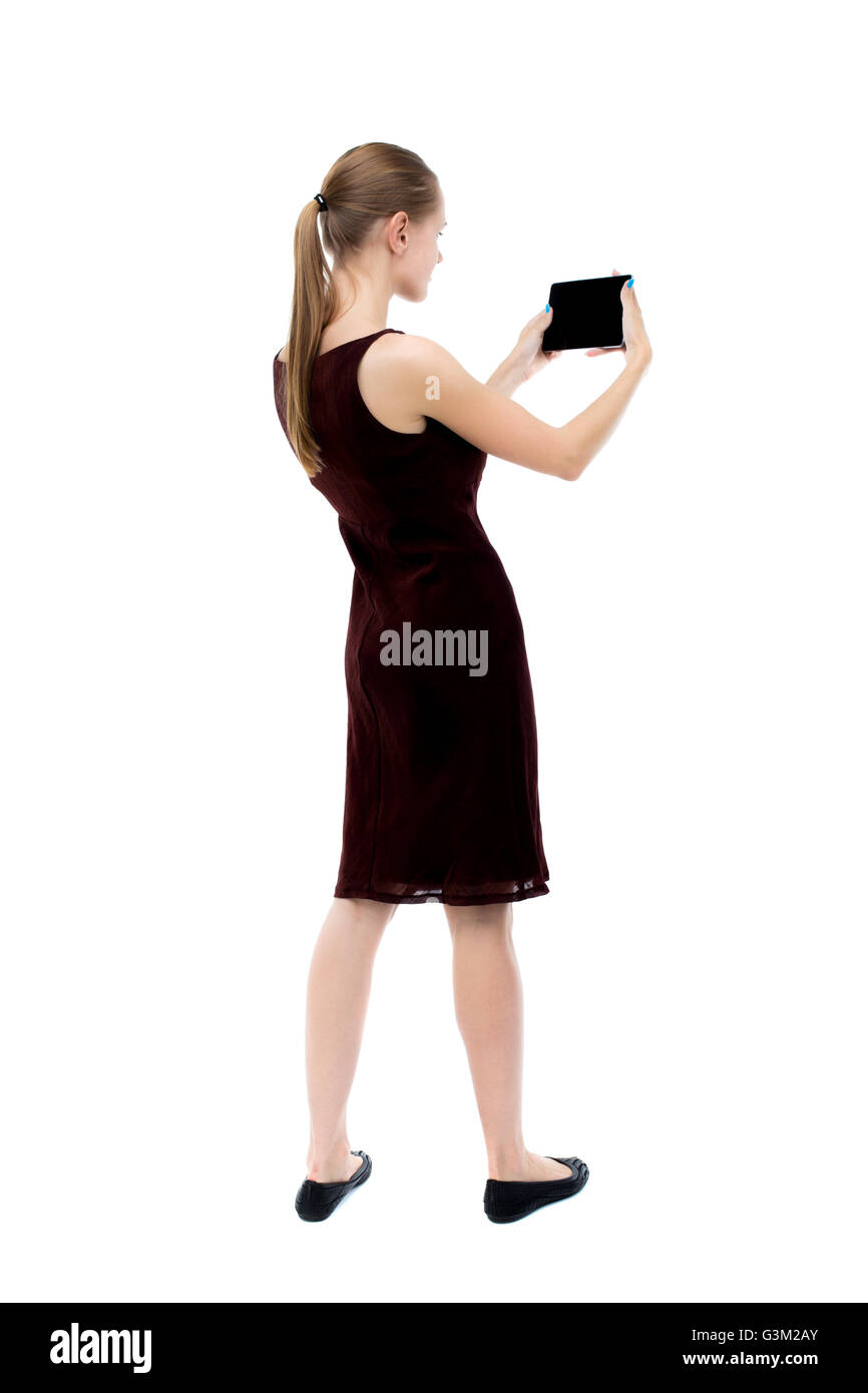back view of standing young beautiful girl with tablet computer in the ...