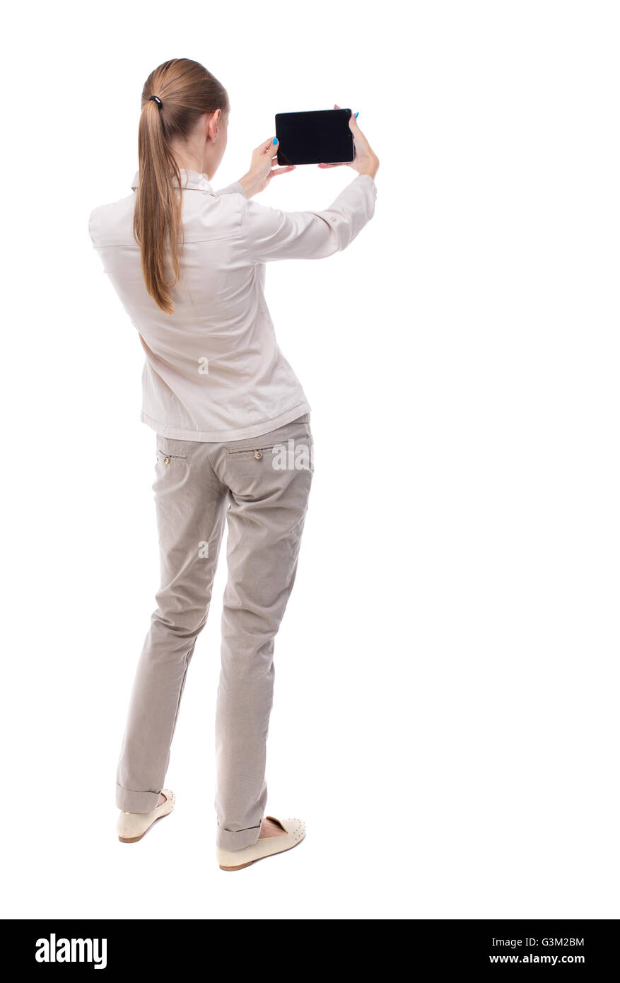 back view of standing young beautiful girl with tablet computer in the ...