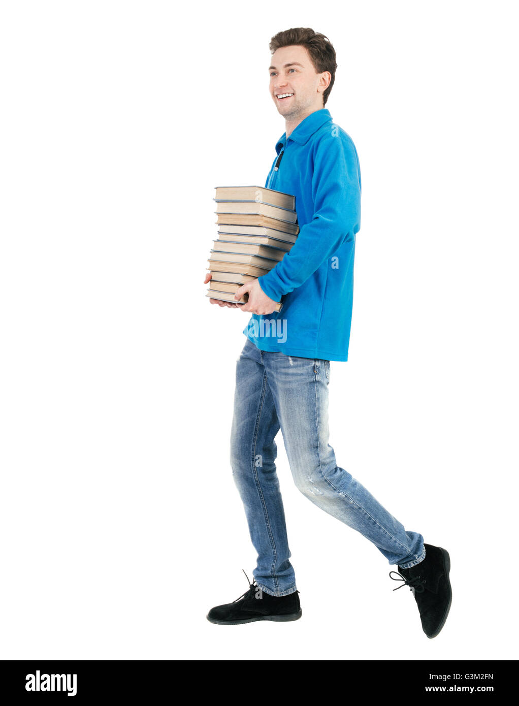 back view of going man carries a stack of books. walking young guy ...