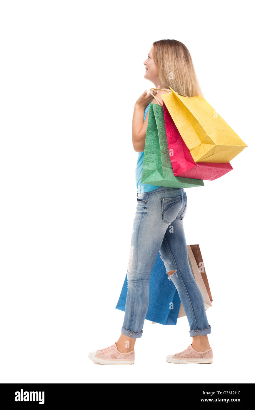 back view of going woman with shopping bags . beautiful girl in motion ...