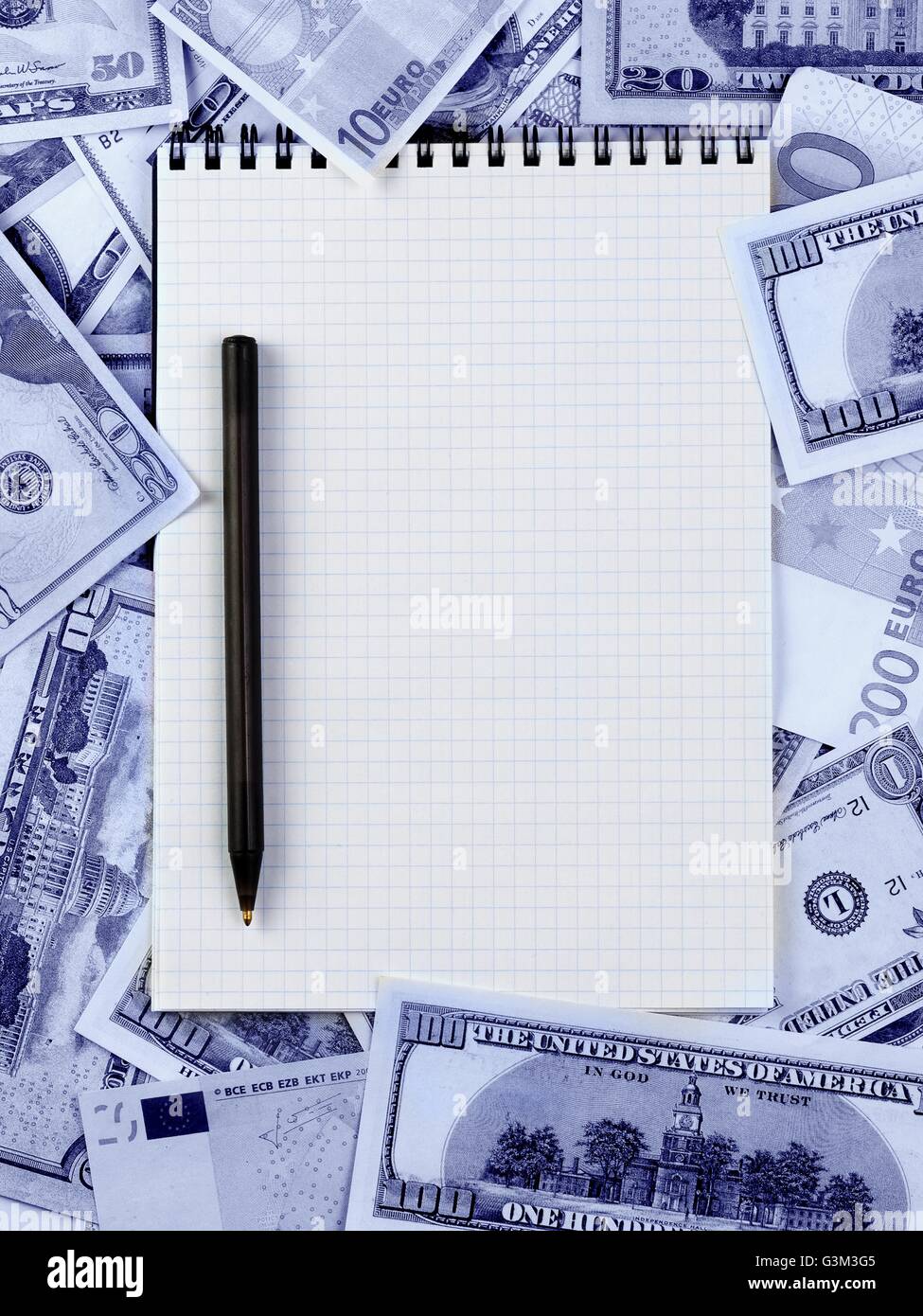 Opened spiral notepad (notebook) sheet in a cage on money background ...