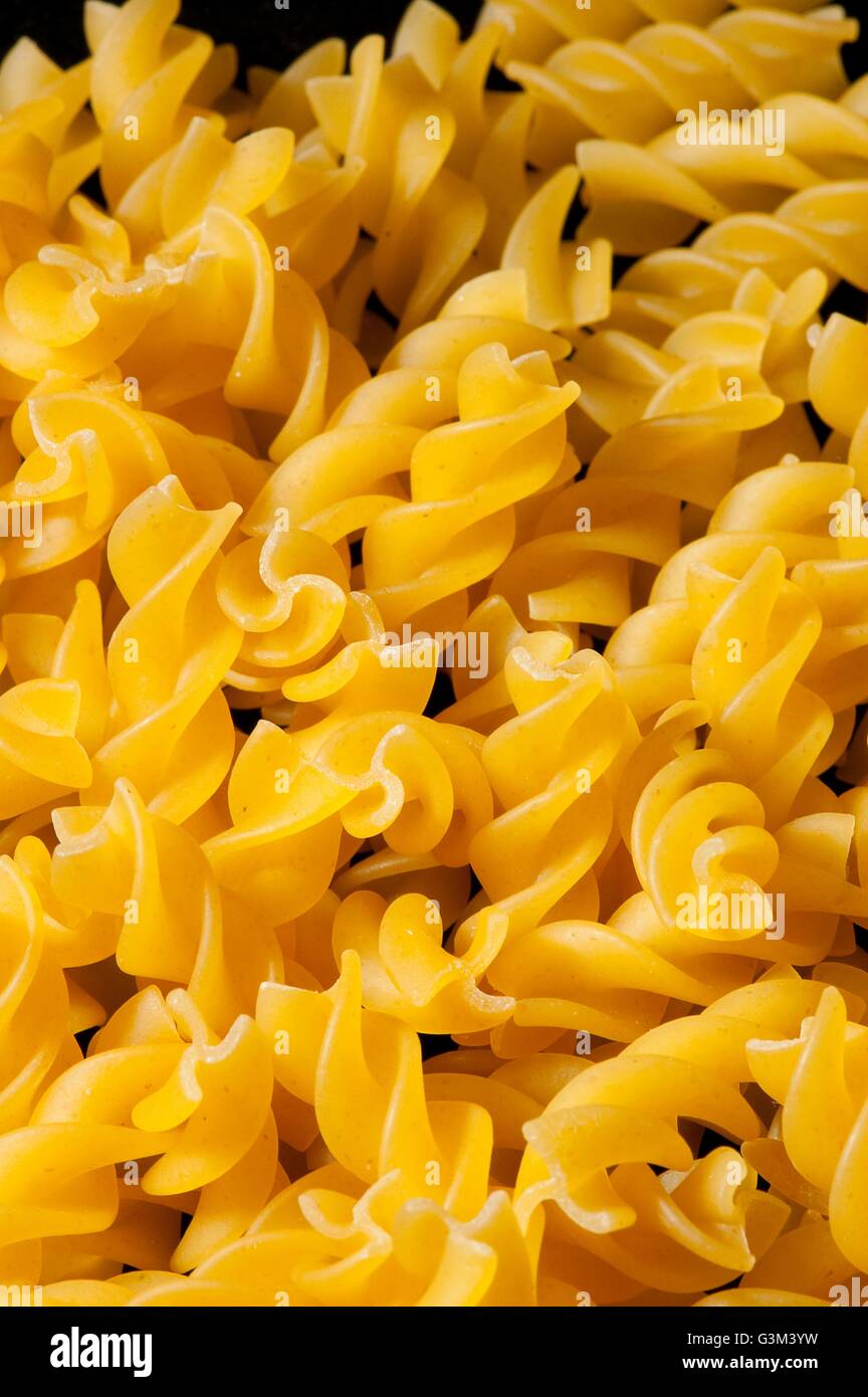 Yellow nice macaroni on black background Stock Photo - Alamy