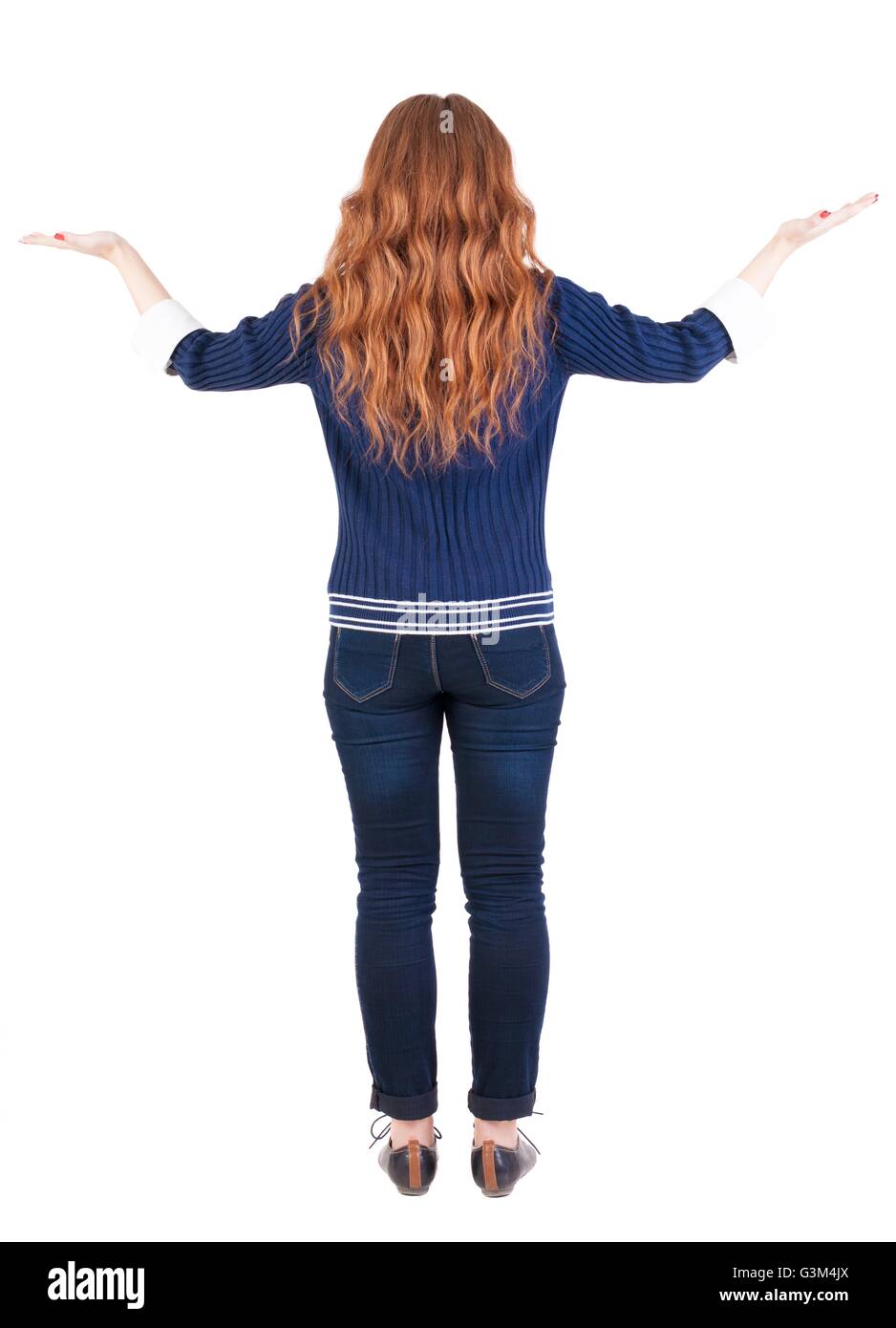 Back view of Beautiful woman looking at wall and Holds a hand up. Rear ...