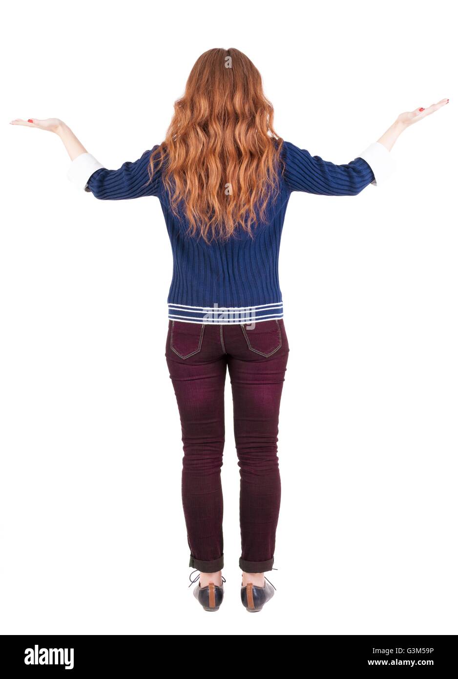 Back view of Beautiful woman looking at wall and Holds a hand up. Rear ...